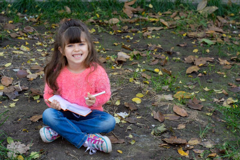 Cute Child Writing in Notebook Using Pen and Smiling. Four Years Old ...