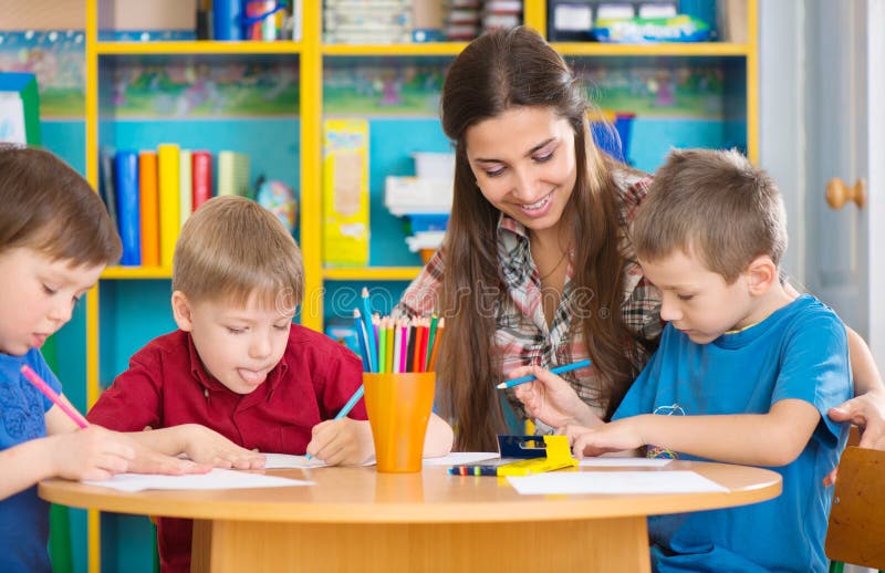 A Female English Teacher Teaching Two Little Boys, Explaining ABC ...