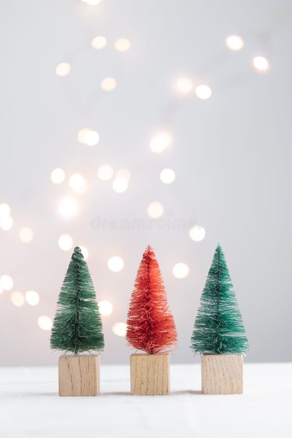 Cute Christmas Miniature Fir Trees on a White Table with Bokeh Lights ...