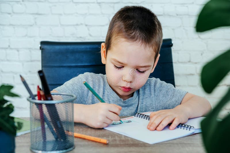 Cute Little Boy Drawing in His Notebook at the Table Stock Image ...