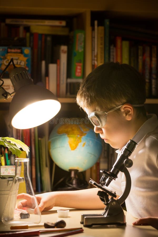 Cute Elementary School Boy Looking into Microscope at His Desk at Home ...
