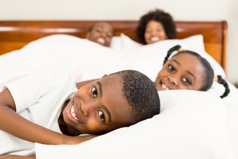 Cute family resting on bed stock image. Image of cushions - 65328873