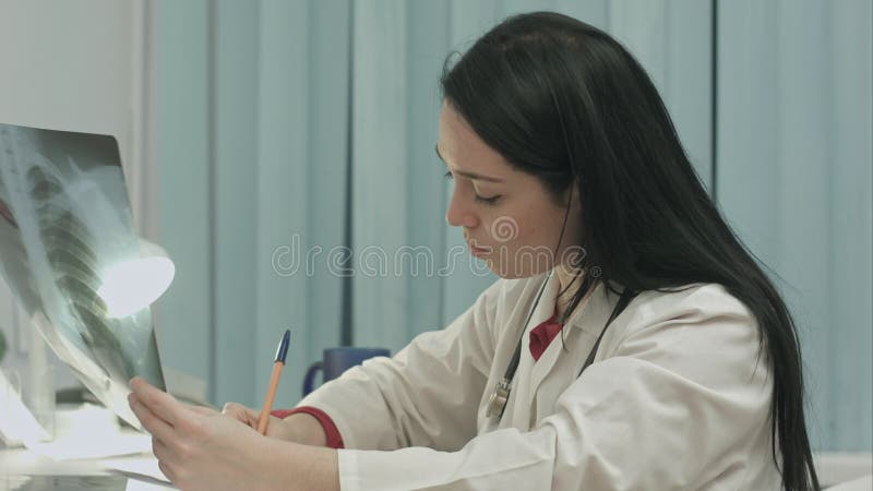 Female X-ray Technician Analyzing Some Results and Taking Notes Stock ...