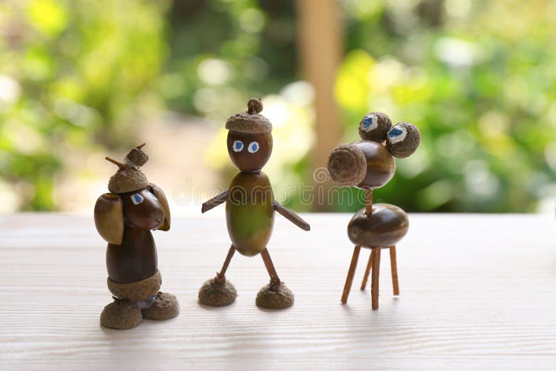 Cute Figures Made of Acorns on White Wooden Table Stock Image - Image ...