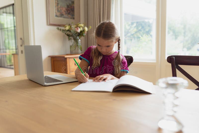 Cute Girl Doing Homework at Dining Table in a Comfortable Home Stock ...