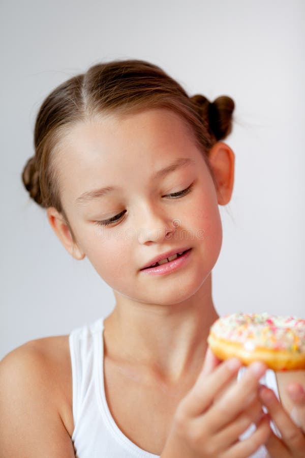 Cute Girl Holding an Appetizing Glazed Donut in Her Hands Stock Photo ...