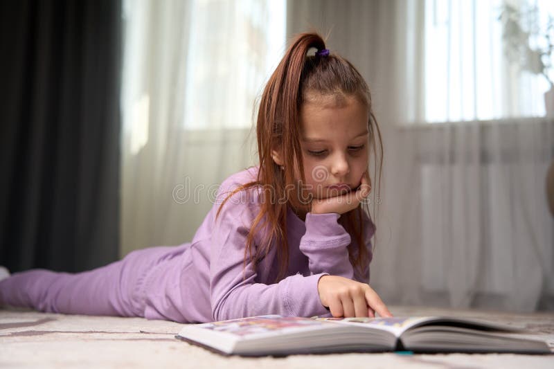 Cute Girl Lying on the Floor and Reading a Book Stock Photo - Image of ...