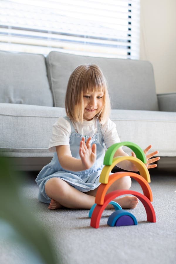 A Cute Girl is Playing an Educational Game with a Wooden Rainbow. Child ...