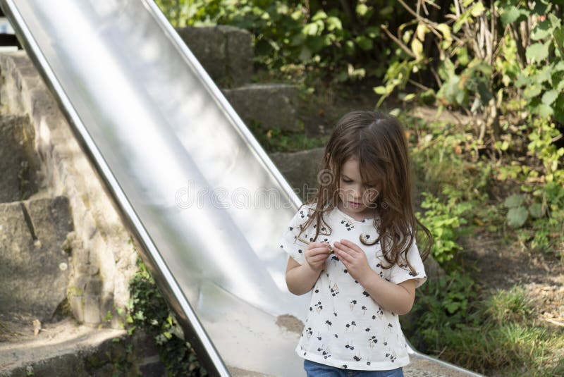 Cute Girl Playing on a Slide in the Park. Selective Focus Stock Image ...