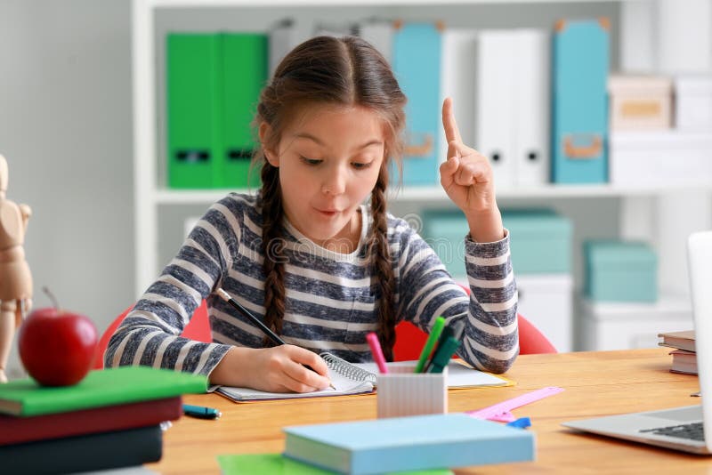 Cute Girl with Raised Index Finger Doing Homework in Classroom Stock ...