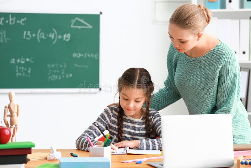 Cute Girl with Teacher Doing Homework in Classroom Stock Image - Image ...