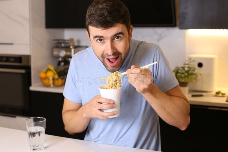 Cute Guy Eating Instant Noodles in the Kitchen Stock Photo - Image of ...