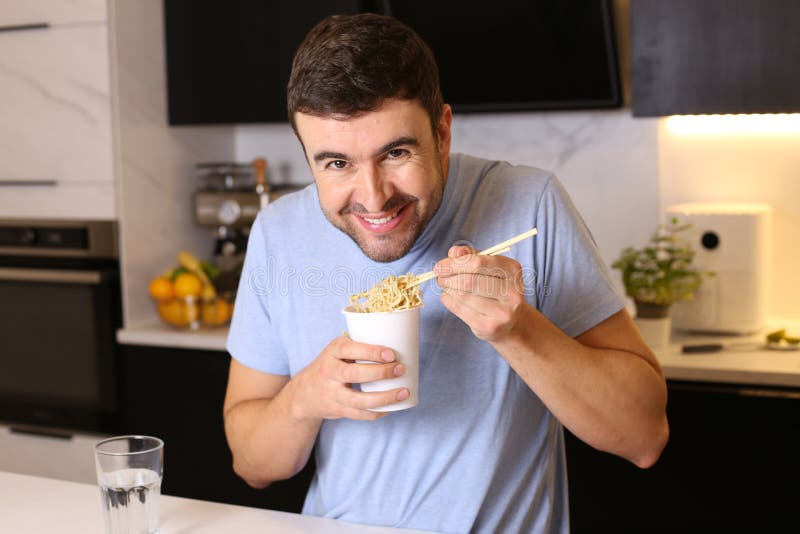 Cute Guy Eating Instant Noodles in the Kitchen Stock Photo - Image of ...