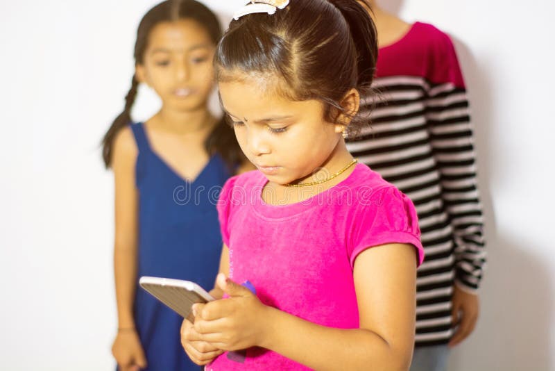 Two Cute Indian Children Busy in Watching Mobile Phone on Bed. Stock ...