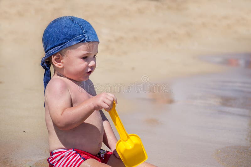 Cute Kid Playing on the Beach with Sand and Water. Stock Photo - Image ...