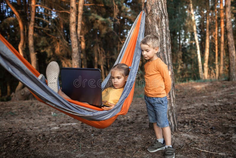 Cute Kid Using Digital Gadget for Reading and Learning in Hammock ...