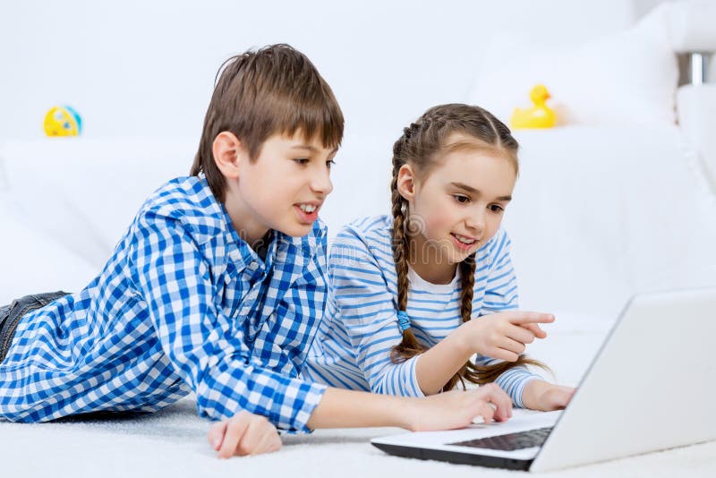 Cute kids using devices stock photo. Image of home, lying - 66496846