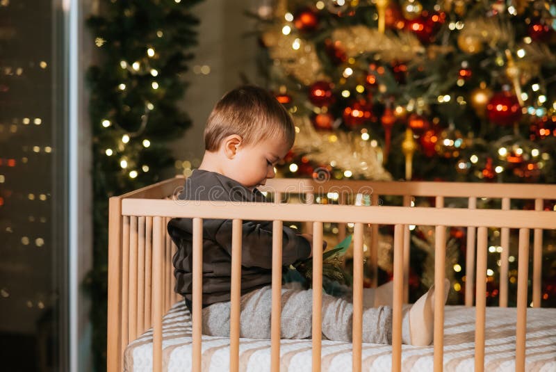 Cute Little Baby on a Crib by a Christmas Tree, Close Up Stock Image ...