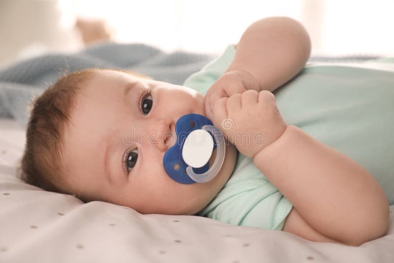 Cute Little Baby with Pacifier on Bed at Home Stock Photo - Image of ...