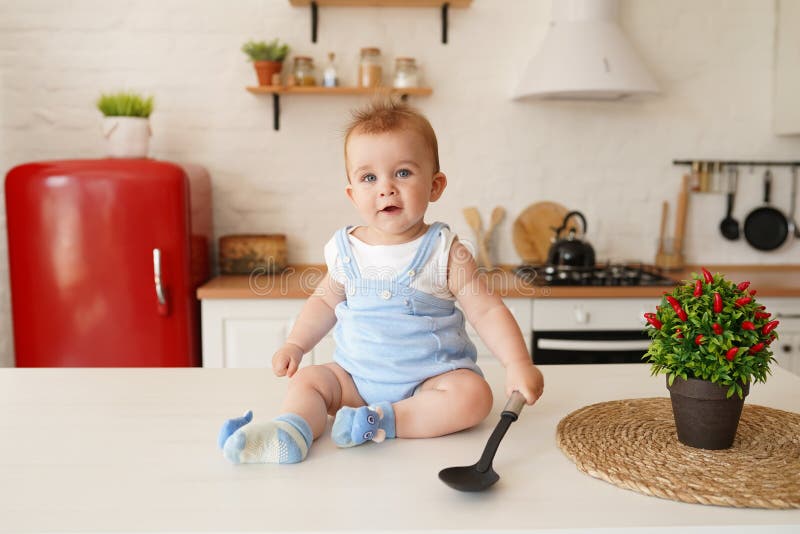 Cute Little Baby Sitting on Kitchen Table and Looking at Camera Stock ...