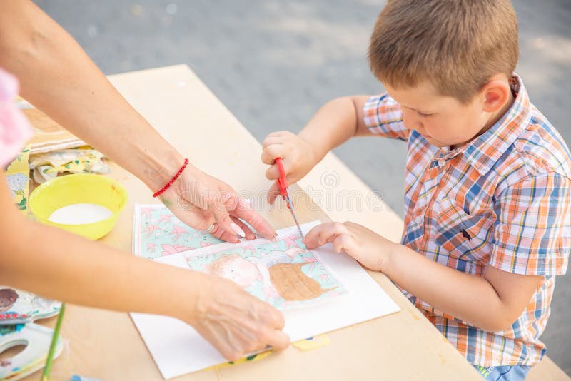 Cute Little Boy Cutting Shapes Out of Colored Paper. Being Creative ...
