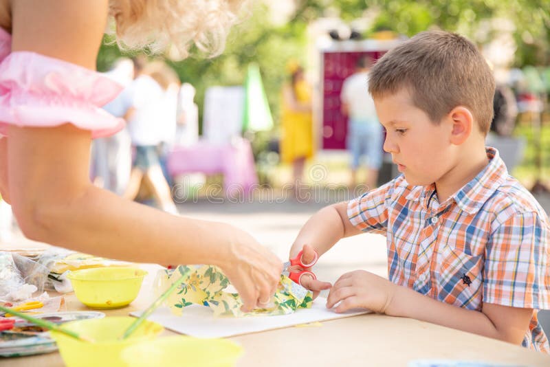 Cute Little Boy Cutting Shapes Out of Colored Paper. Being Creative ...