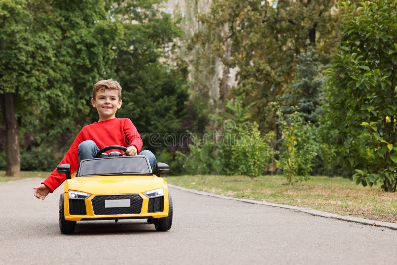 Cute Little Boy Driving Children`s Car Outdoors. Space for Text Stock ...