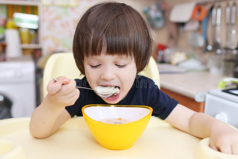 Boy Eats Soup with Fresh Onions. Preschool Boy Holds a Spoon in His ...