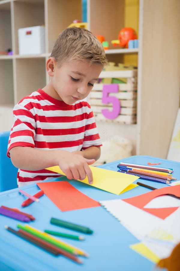 Cute Little Boy Folding Paper Shapes in Classroom Stock Photo - Image ...