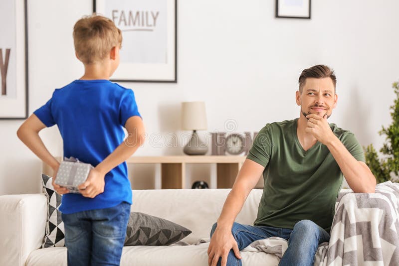 Cute Little Boy Holding Gift for Father Behind His Back at Home Stock ...