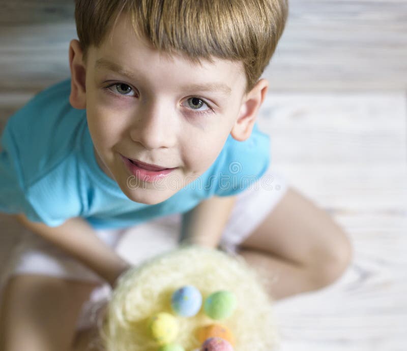 Cute Little Boy Holding a Nest with Colored Easter Eggs at Home on ...