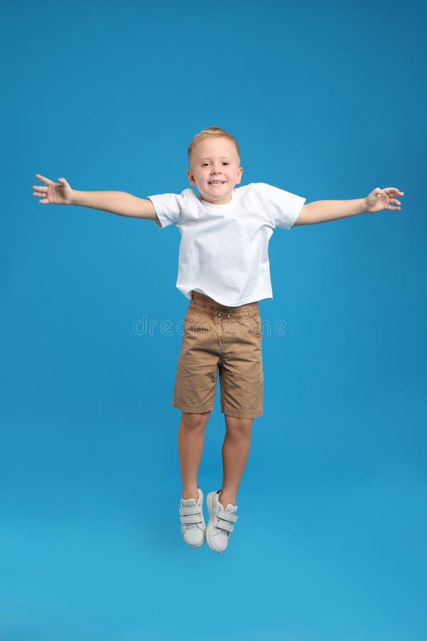 Cute Little Boy Jumping on Blue Background Stock Image - Image of ...