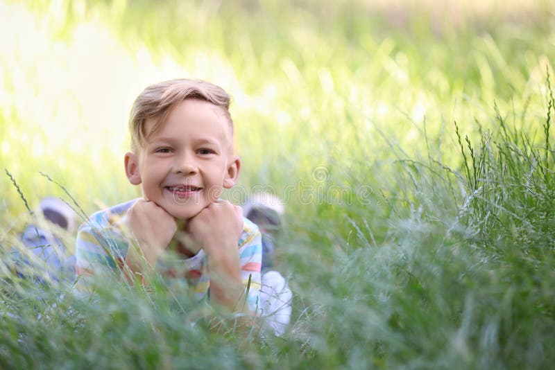 Cute Little Boy Lying on Green Grass Outdoors Stock Image - Image of ...