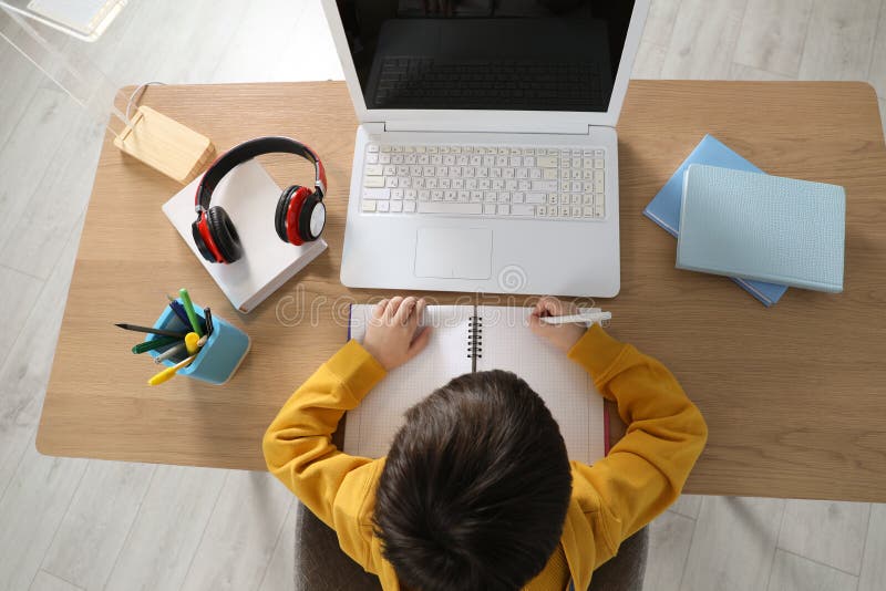 Cute Little Boy with Modern Laptop Studying Online at Home, Top View. E ...