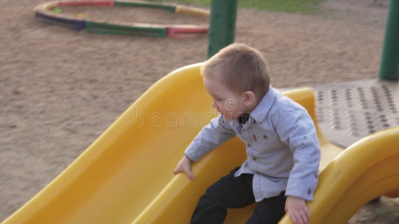 Little Boy Moving Down from Children`s Slide on Playground Stock Video ...