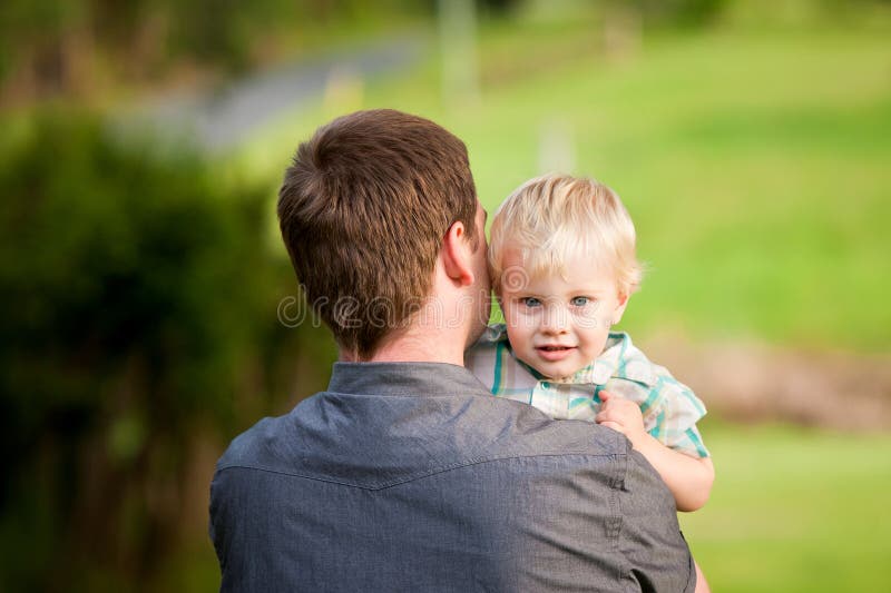 A Cute Little Boy Peers Over His Dad S Shoulder Stock Photo - Image of ...