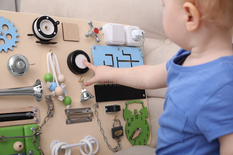 Cute Little Boy Playing with Busy Board on Sofa Stock Photo - Image of ...