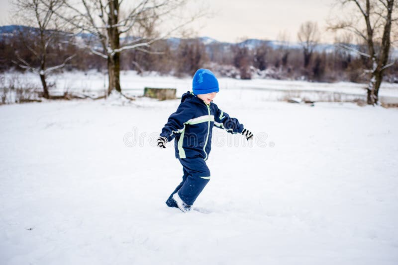 Little boy playing in snow stock image. Image of enjoyment - 110275297