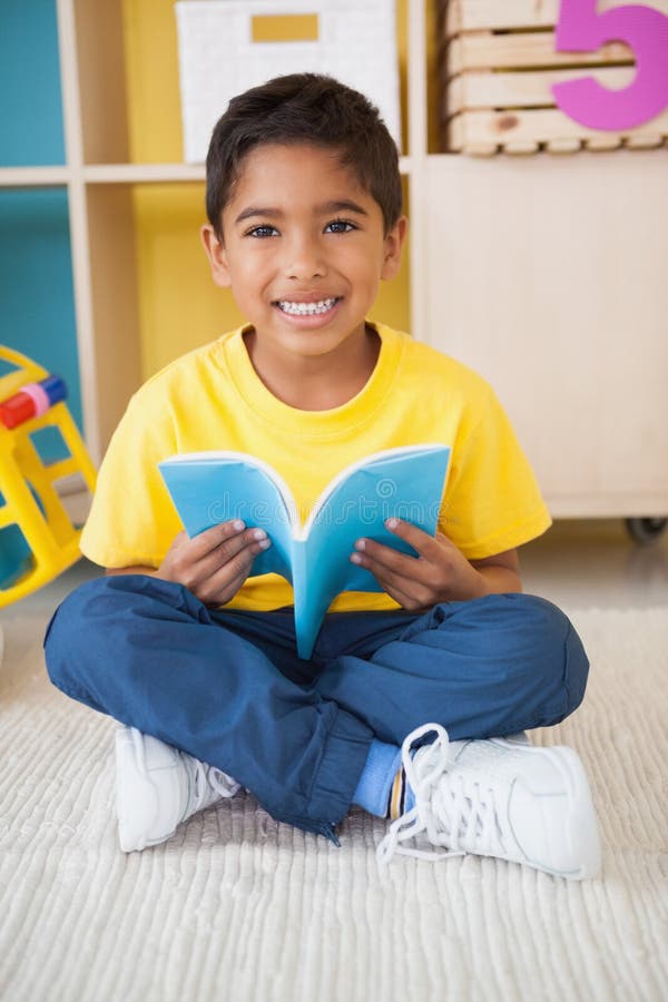 Cute Little Boy Sitting on Floor Reading in Classroom Stock Image ...