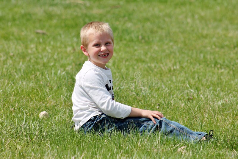 Cute Little Boy Sitting in the Grass Stock Photo - Image of jeans ...