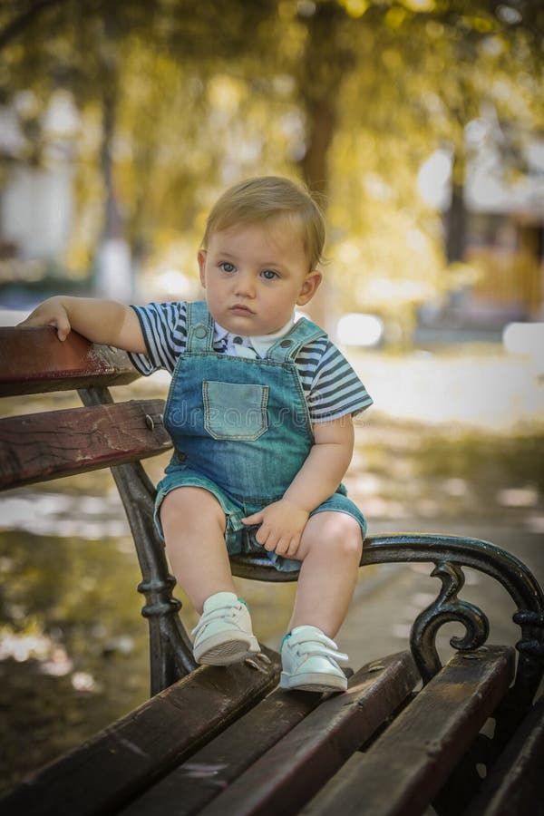 Cute Little Boy Standing in the Park on a Bench Standing and Looking ...