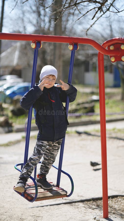 Cute Little Boy on a Swing at the Playground Stock Photo - Image of ...