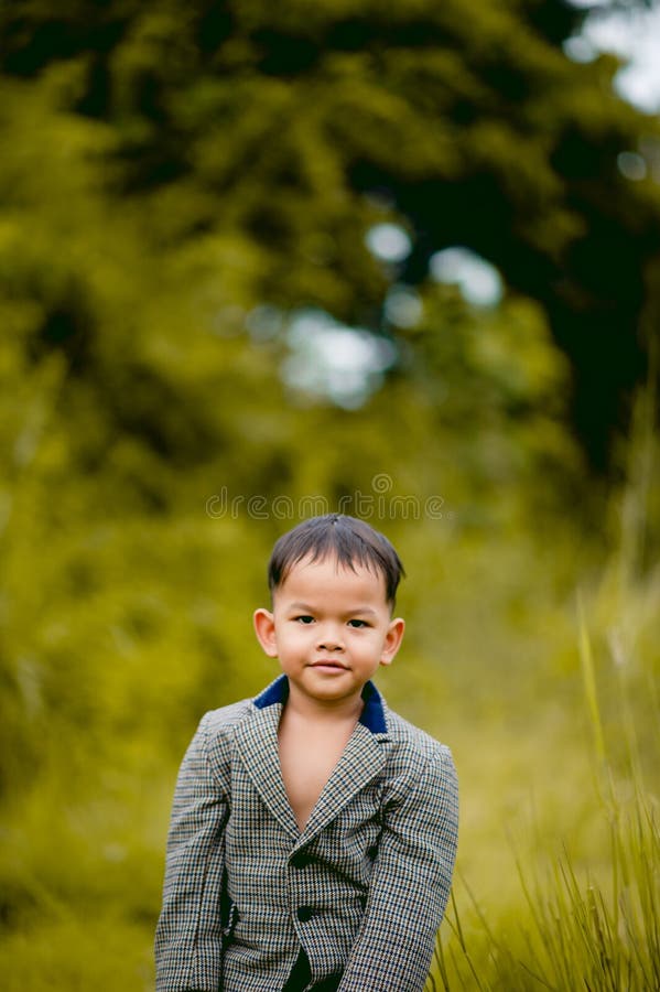 Little Boy a Well-dressed Boy in a Suit in a Backyard with a Lawn and ...