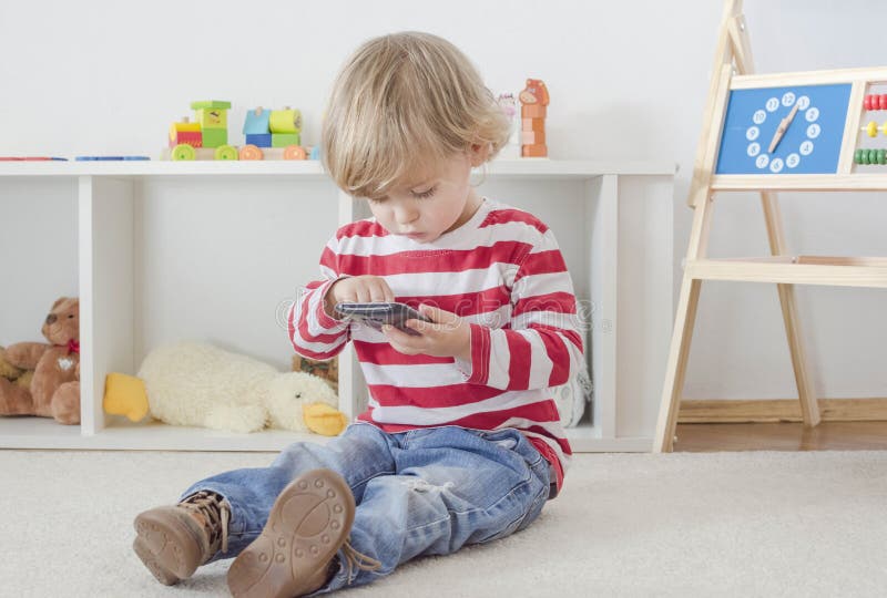 Cute Little Child Using a Smartphone while Sitting on the Floor at Home ...