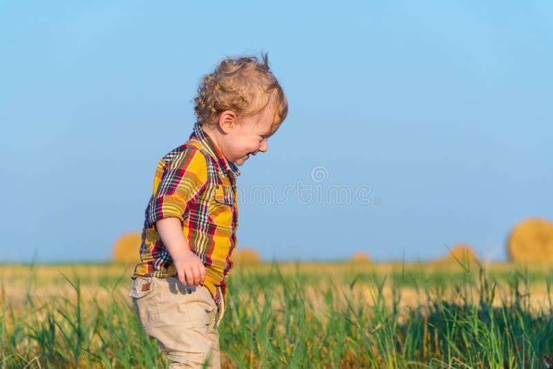 Cute Little Fair-haired Boy Playing on a Wheat Field with Bales Stock ...