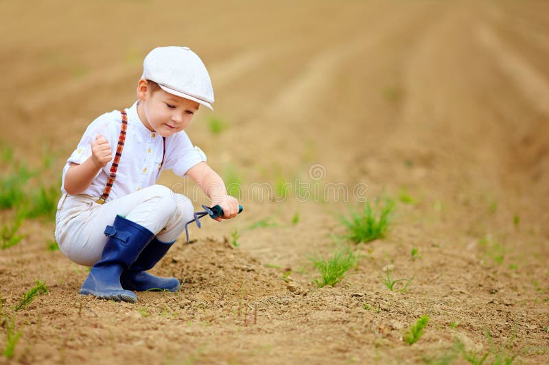 Cute Little Farmer Working with Spud on Spring Field Stock Photo ...