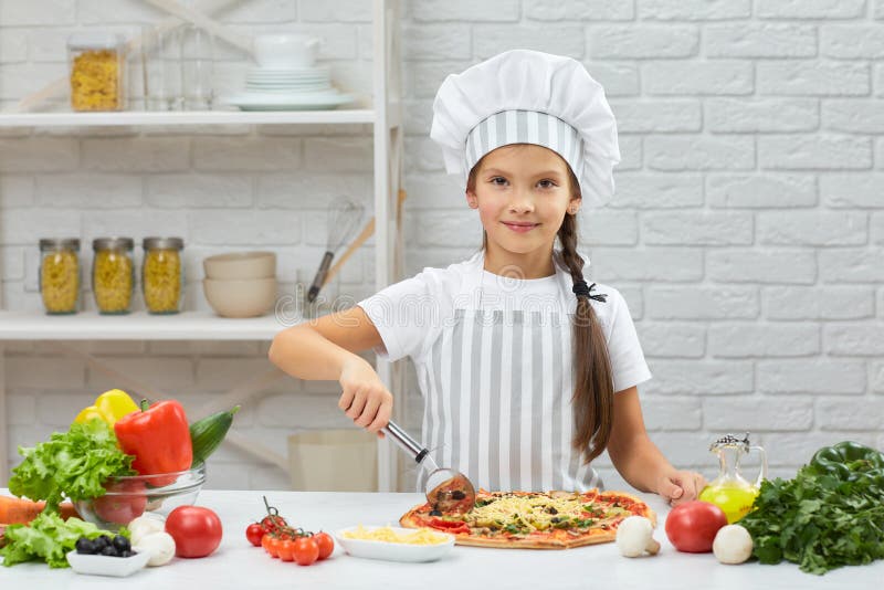 Cute Little Girl in Chef Hat and an Apron Cutting Pizza Stock Image ...