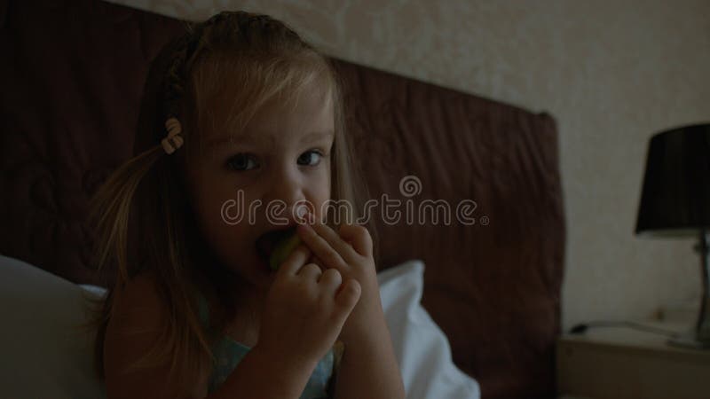 Cute Little Girl Chewing the Apple Stock Photo - Image of indoors ...