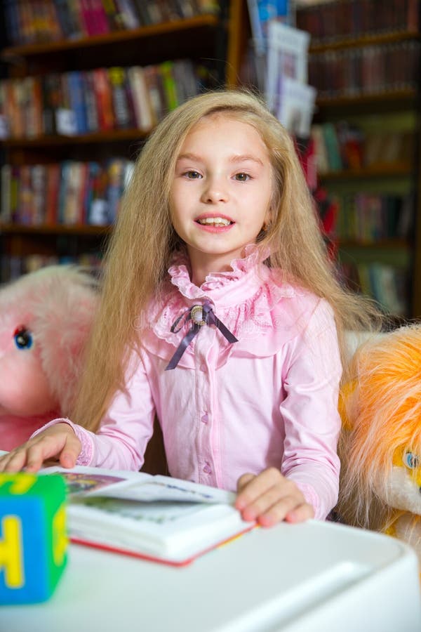 Cute Little Girl Chooses a Book in the Library Stock Photo - Image of ...