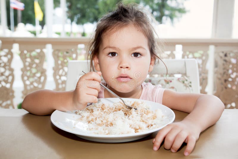 Cute Little Girl Eats Rice in a Summer Cafe Stock Image - Image of eats ...